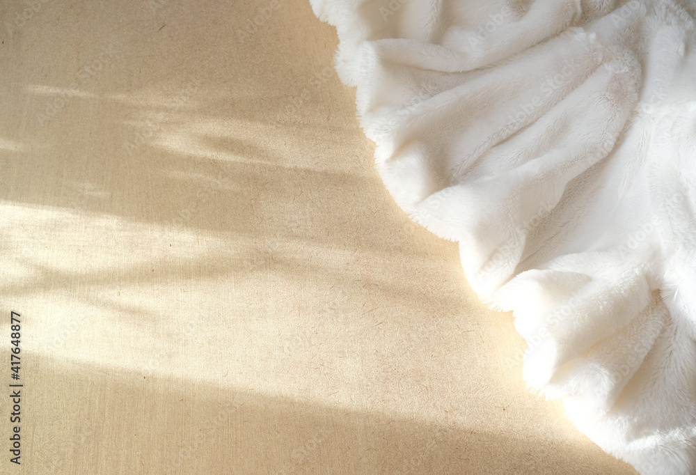 White delicate soft background of plush fabric folds on light golden ...
