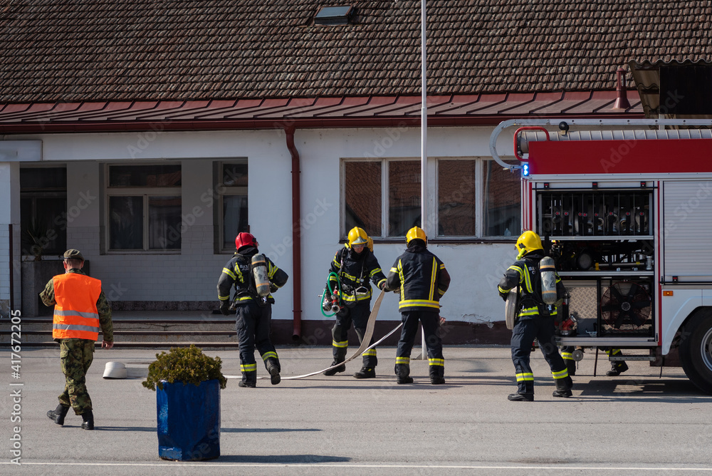 firefighters in the action of extinguishing fires and rescuing injured ...
