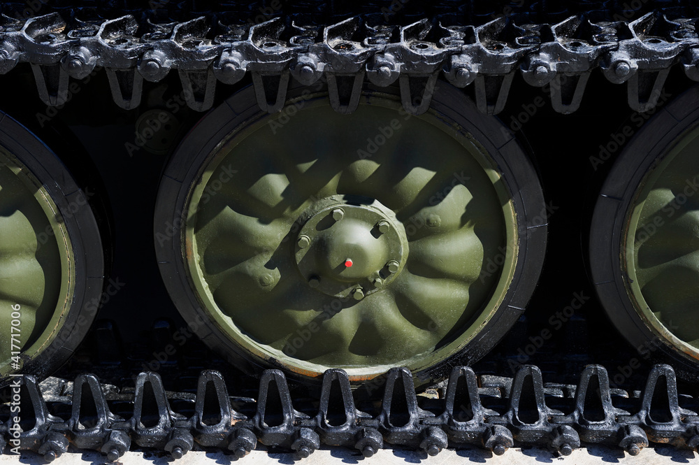 Tank tracks and steel wheels of green color, military industry, modern ...