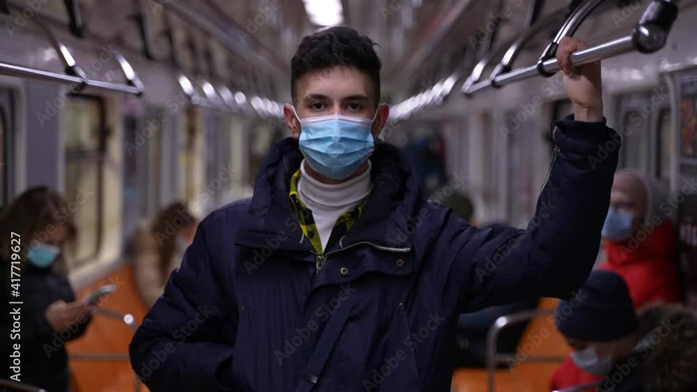 Tall young man wearing medical protective mask and winter jacket ...