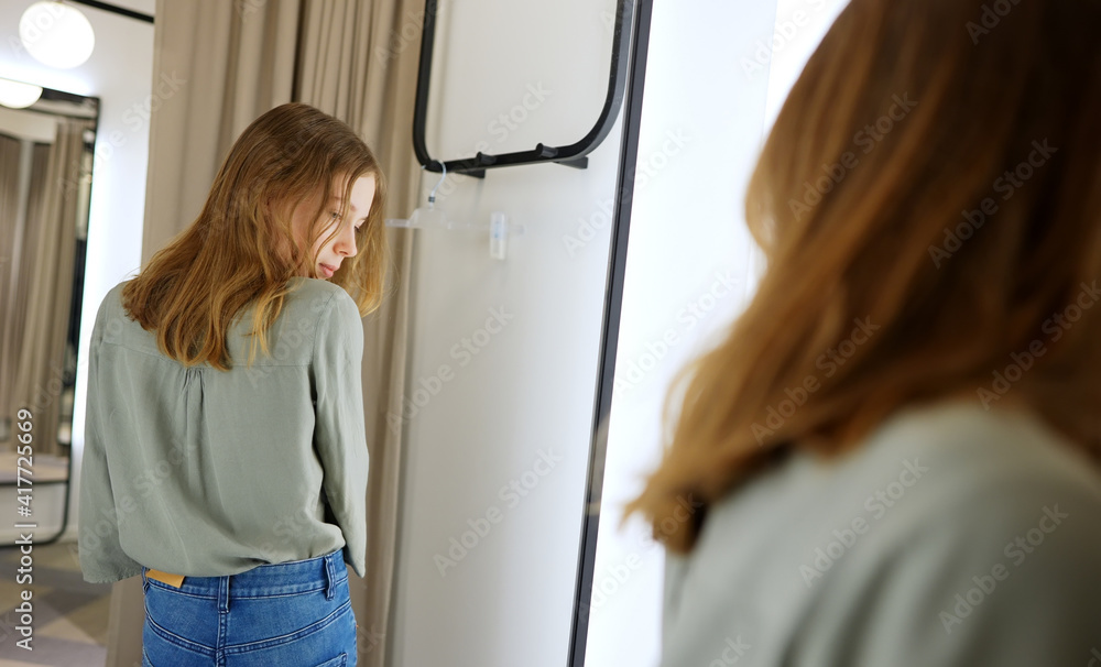 Tween girl standing in fitting room in clothing store. Stock Photo ...