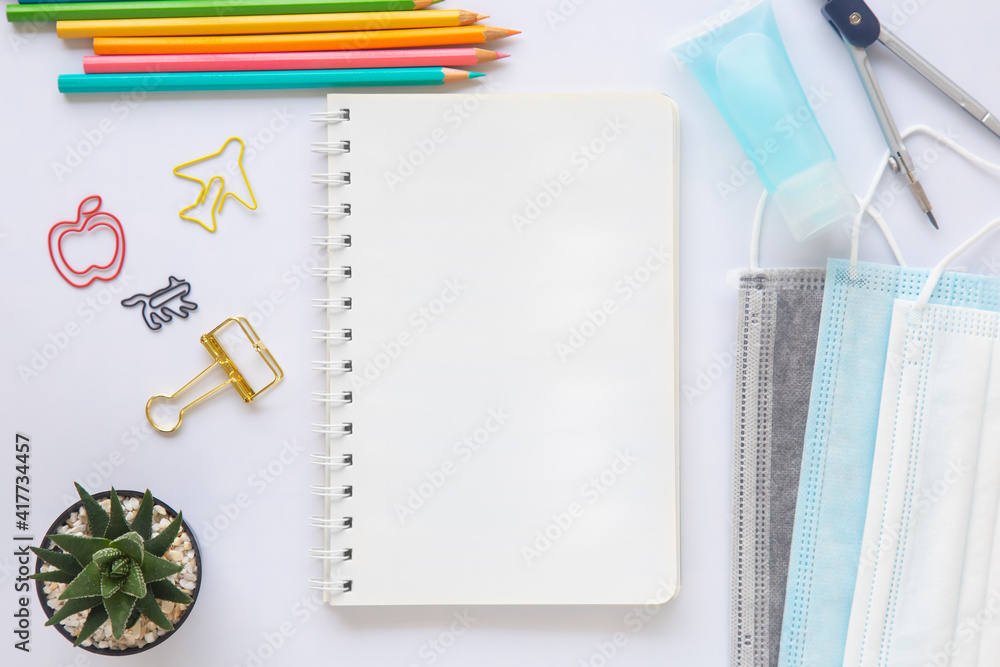 Blank white paper or notebook with stationary, mask and hand sanitizer ...