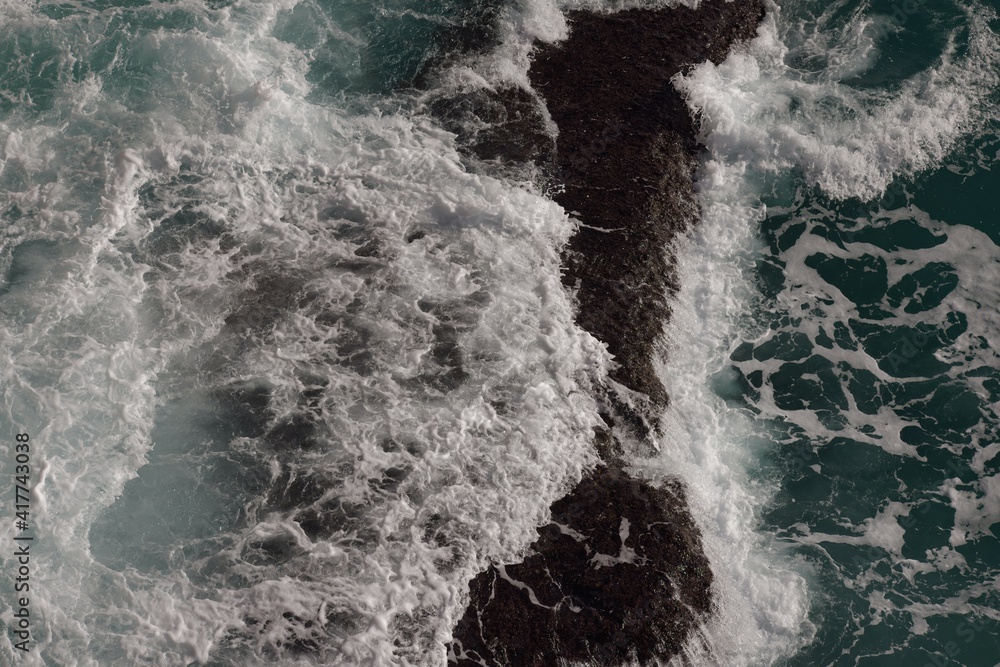 angry waves and waterfalls in the blue sea water ocean coast rocks ...