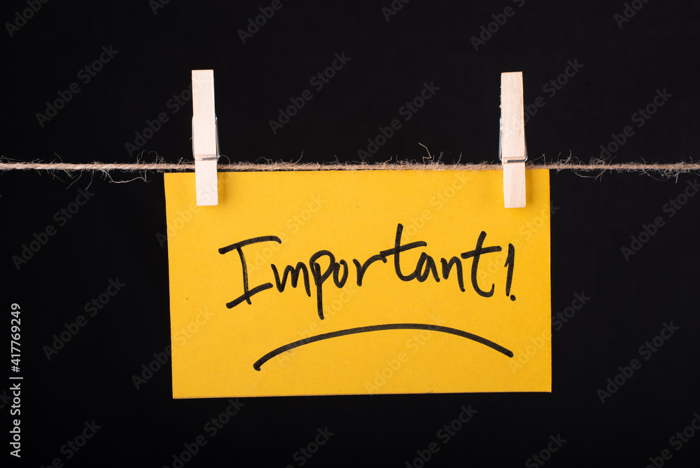 Important word written on a Yellow color sticky note hanging with a ...