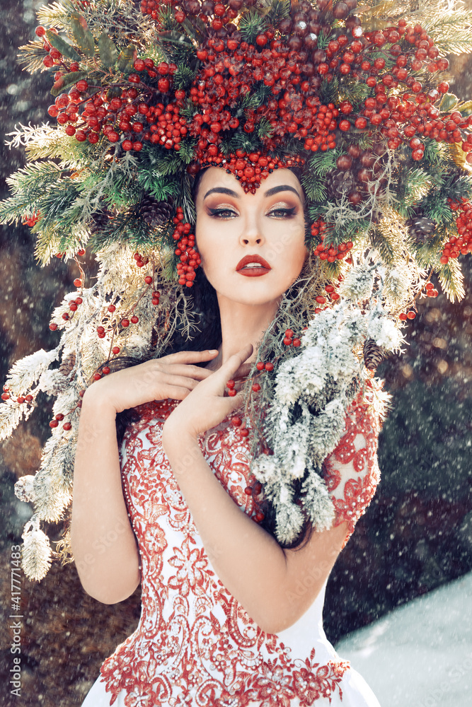 fantasy winter queen standing in the forest in falling snow, a ...