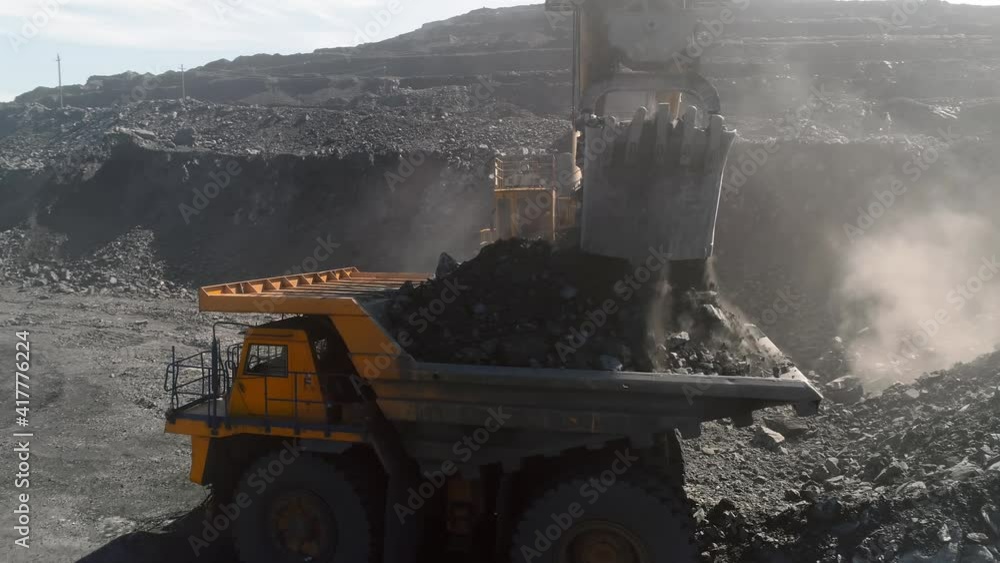 Large quarry dump truck. Loading rock in dumper. Loading coal into ...
