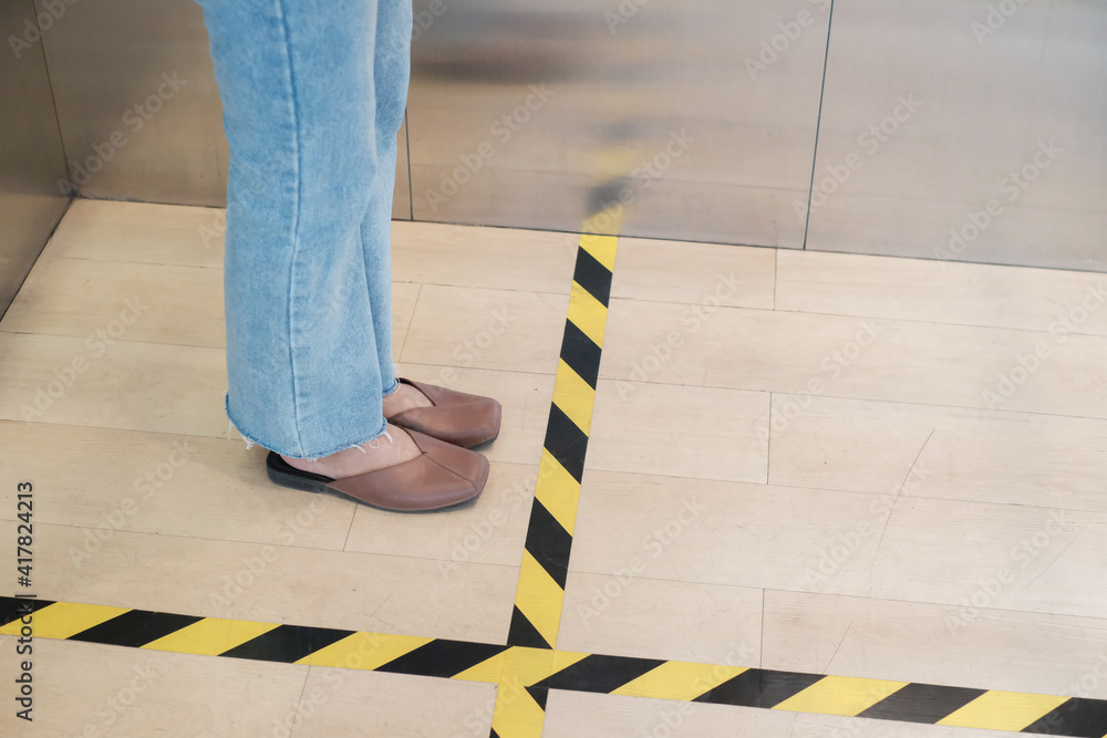 People stand on designated areas to ensure social distancing inside an ...