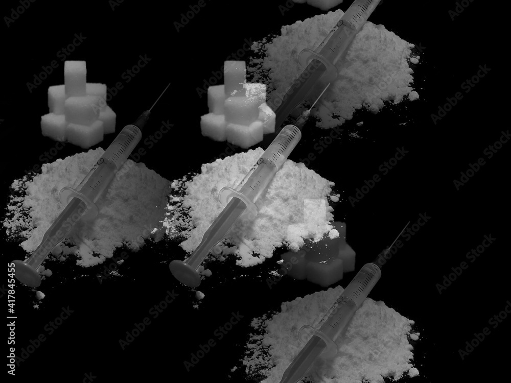 Injection syringe on cocaine drug powder pile and lump sugar cubes on ...