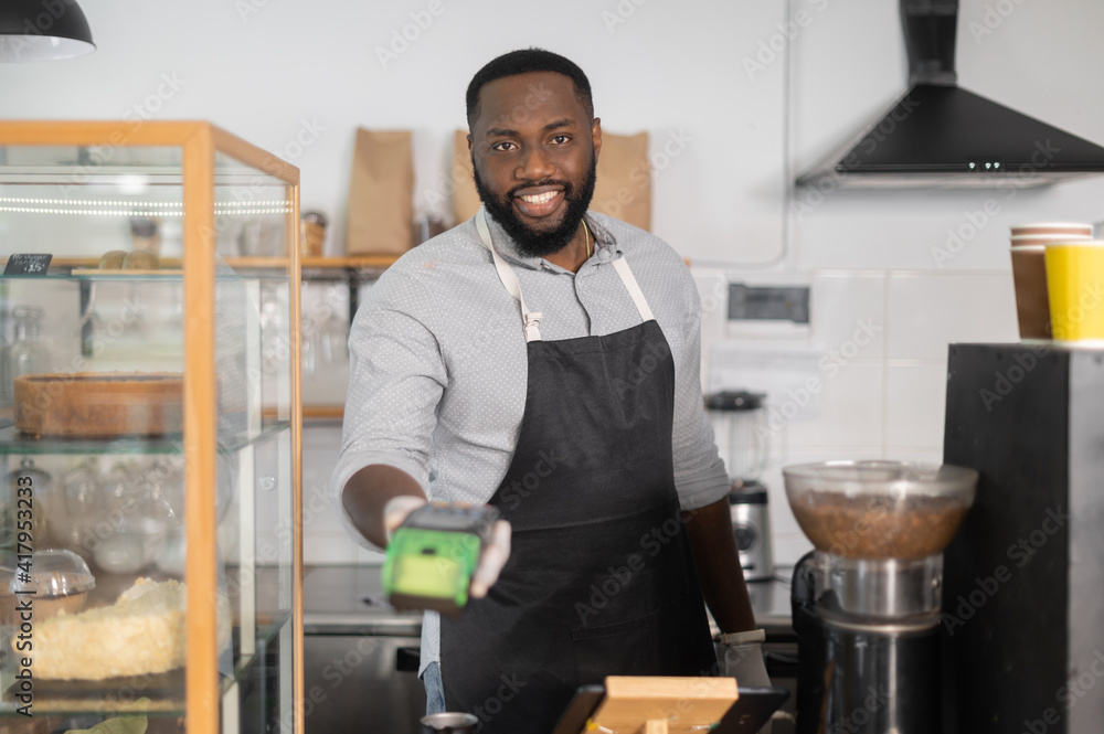 Cheerful and friendly multiracial waiter, African cafe manager, bakery ...