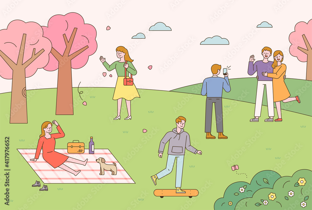 People are doing outdoor activities in a park where spring flowers ...