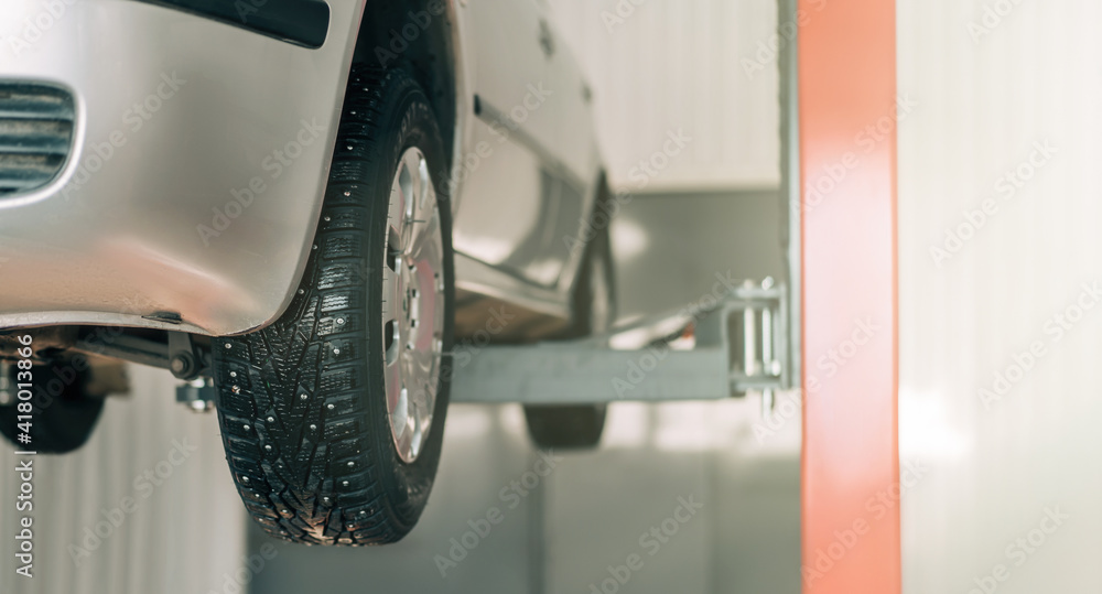 The machine is lifted on a car lift for repair. Side view of the car ...