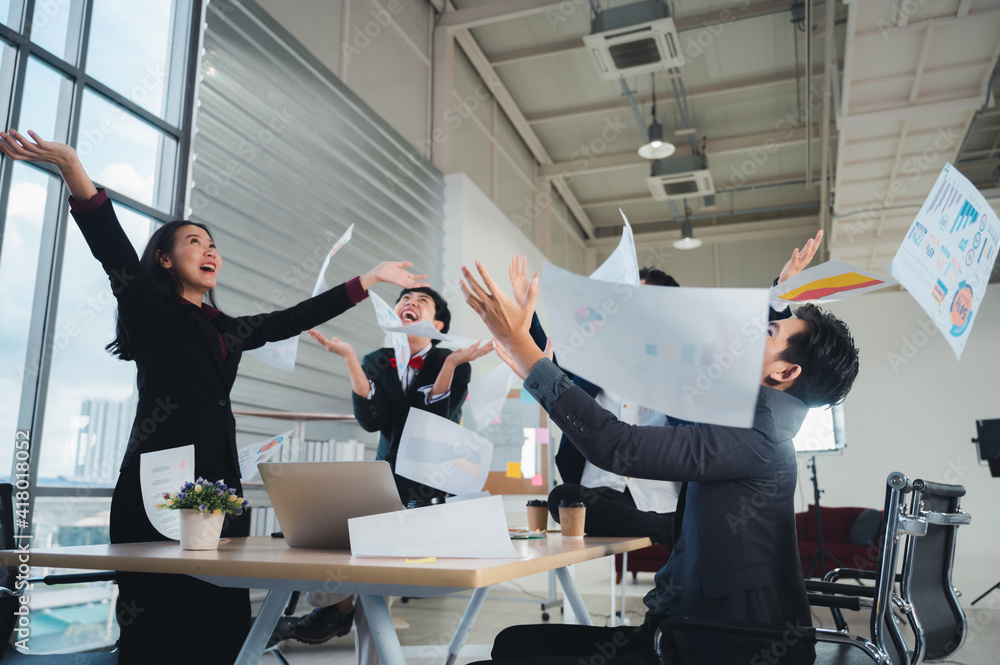 Team of LGBT business people throws paper in joy of meeting their goals ...