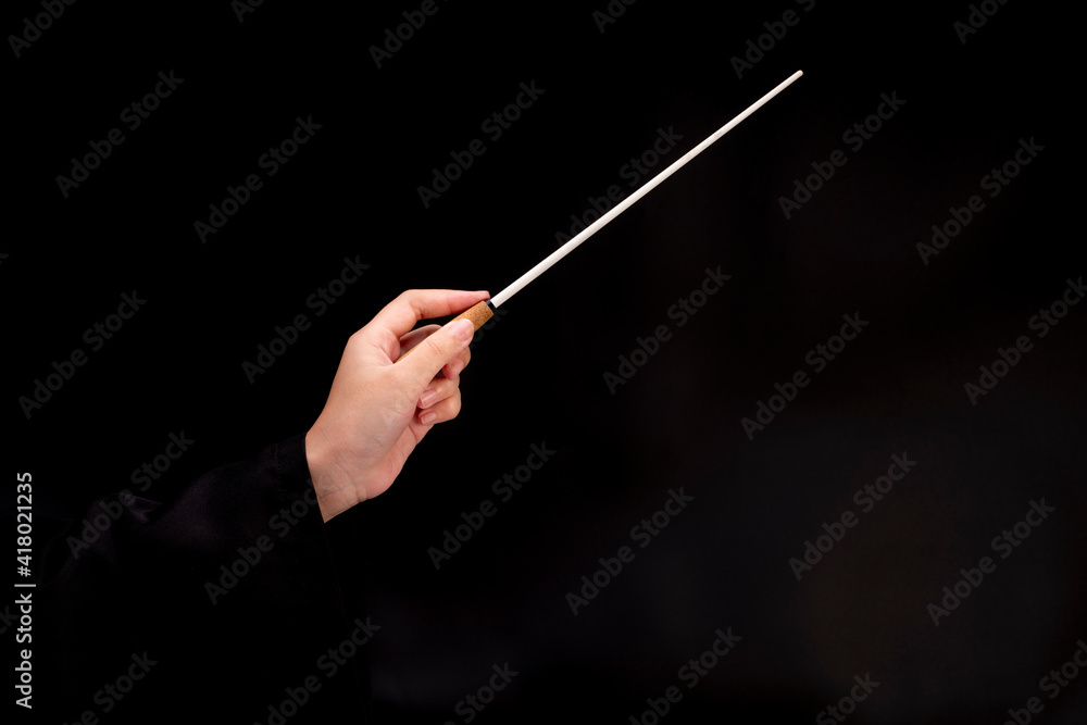 Woman hand holding Baton or Magic wand conjured up in the air. on black ...