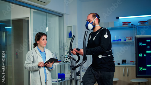 Monitor showing EKG reading of athlete running on cross trainer, while ...