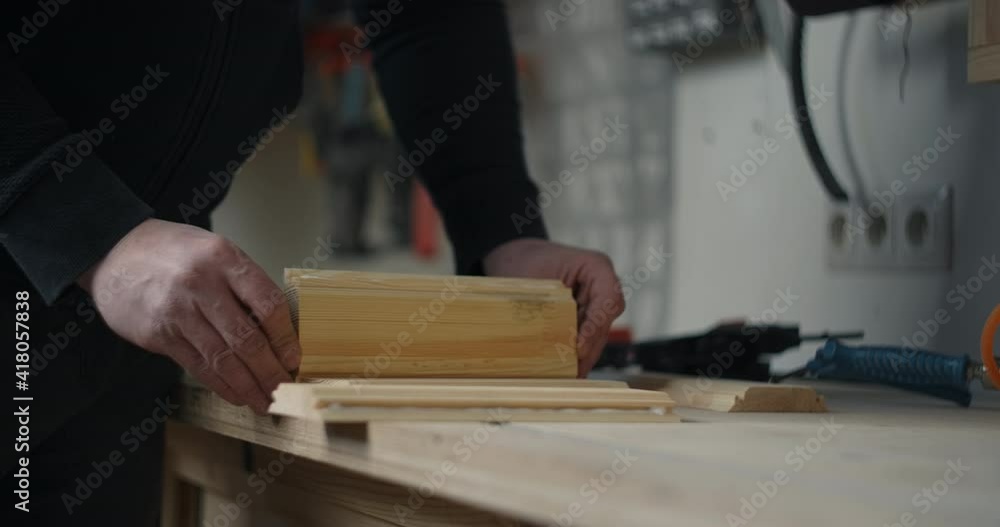 Carpenter glues the timber billets, craftsman at workshop, gluing wood ...