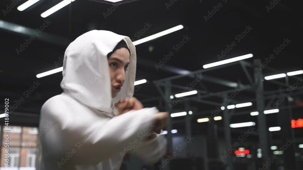 Muslim female boxer in a sports hijab is engaged in boxing, an Arab ...