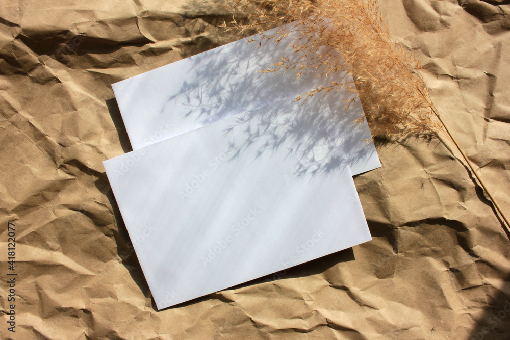 Blank white paper card and dry pampas grass on crumpled kraft paper ...