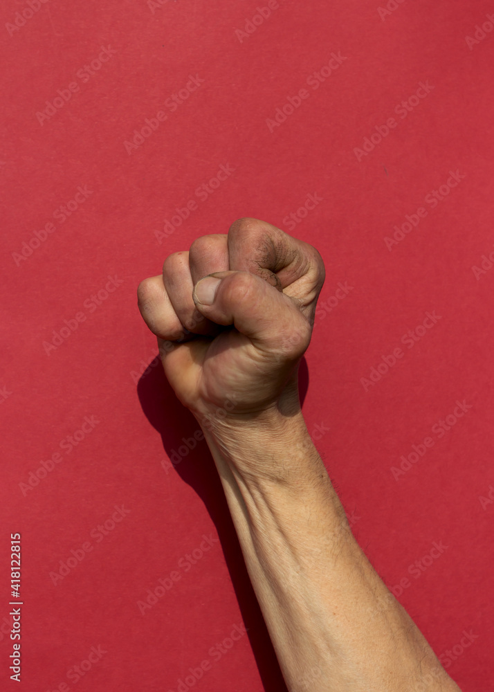 Swarthy rough mans hand with clenched fist on red background. Cesar ...
