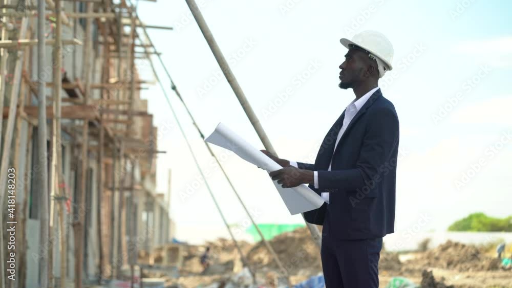 african american architect checking construction site with blueprint ...