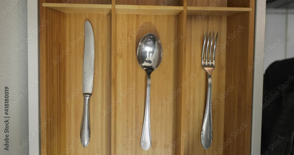 One piece of all types of cutlery in the drawer of the kitchen cabined ...