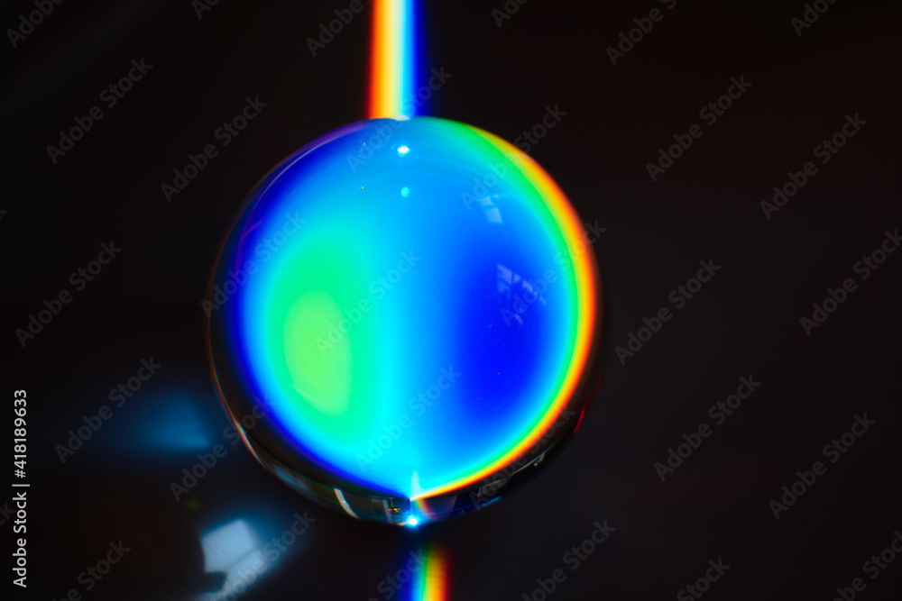 Fotka „Rainbow beam being bent through the refraction of a glass marble ...
