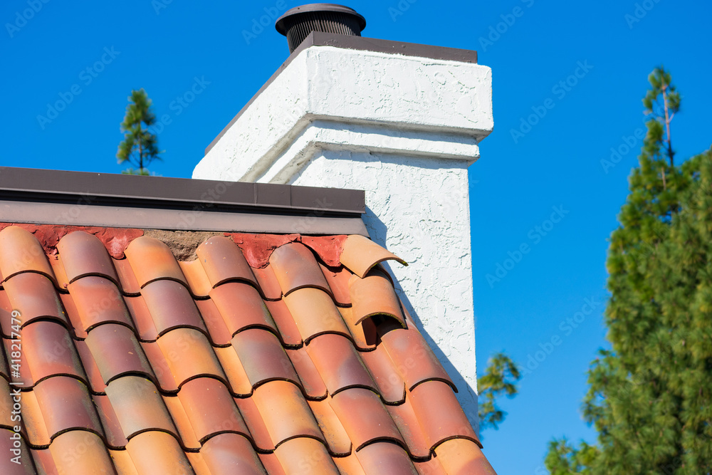 Clay tile rooftop with several roof tiles dislodged by strong winds ...