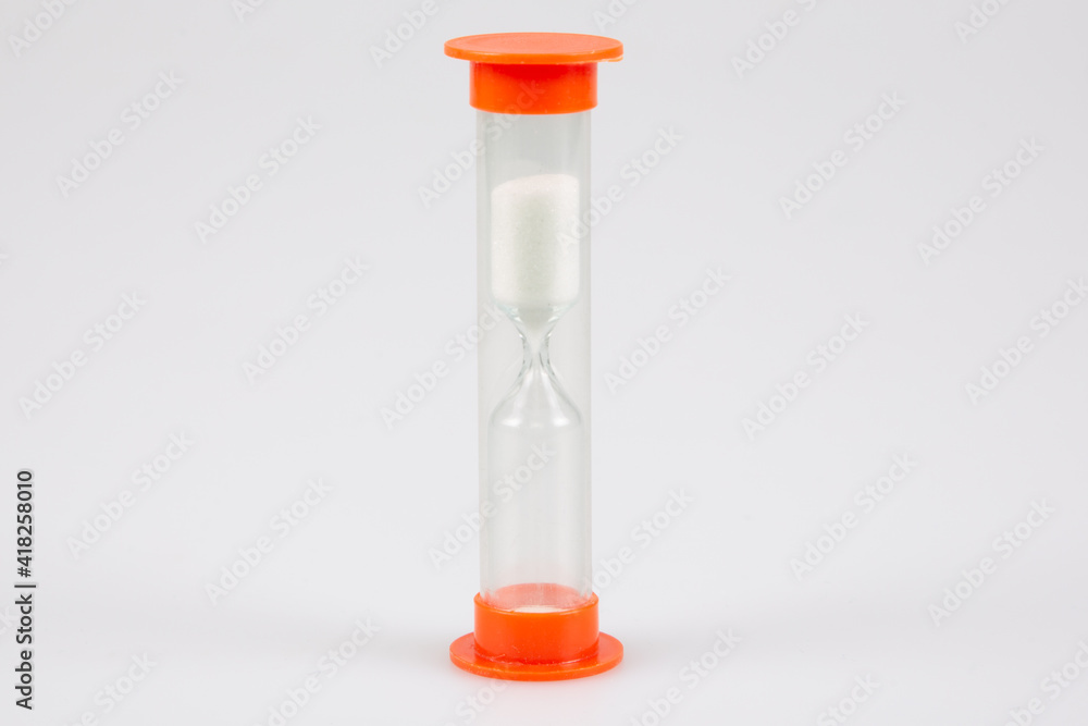 hourglass timer orange in plastic in grey background with white powder ...