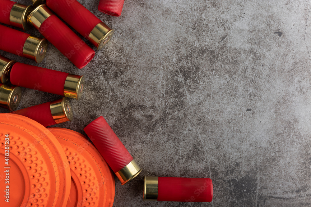 Clay disc flying targets and shotgun shells on texture background ,Clay ...