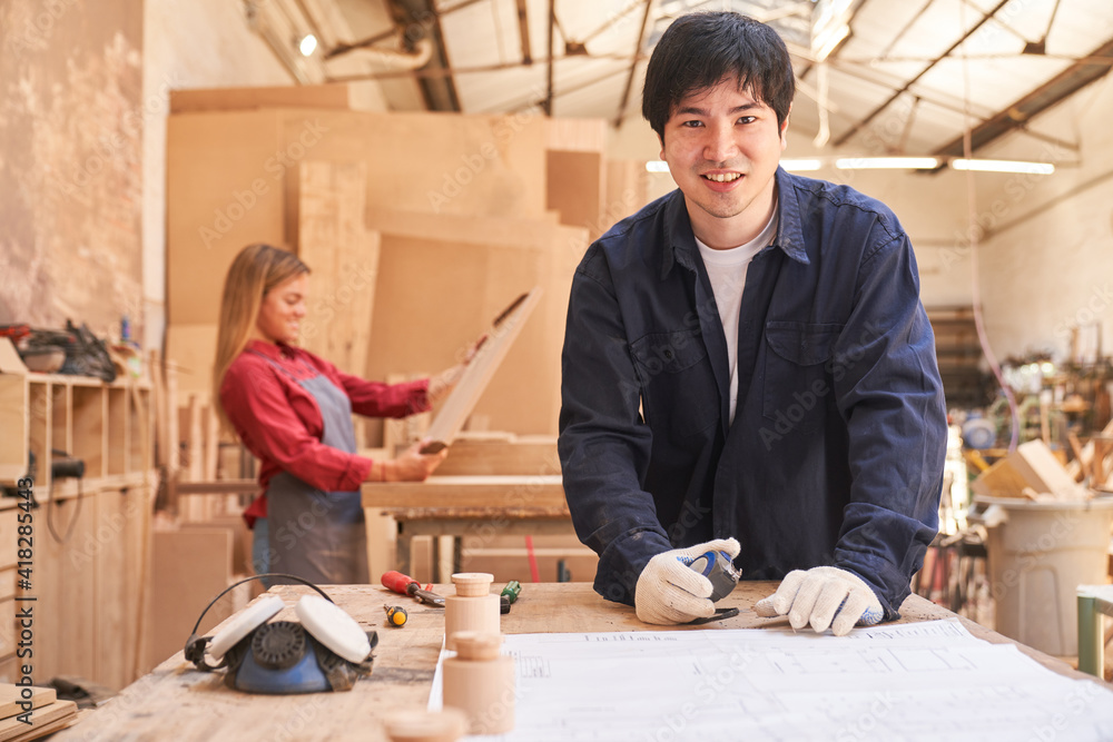 Carpenter apprentice in training with construction plan Stock Photo ...