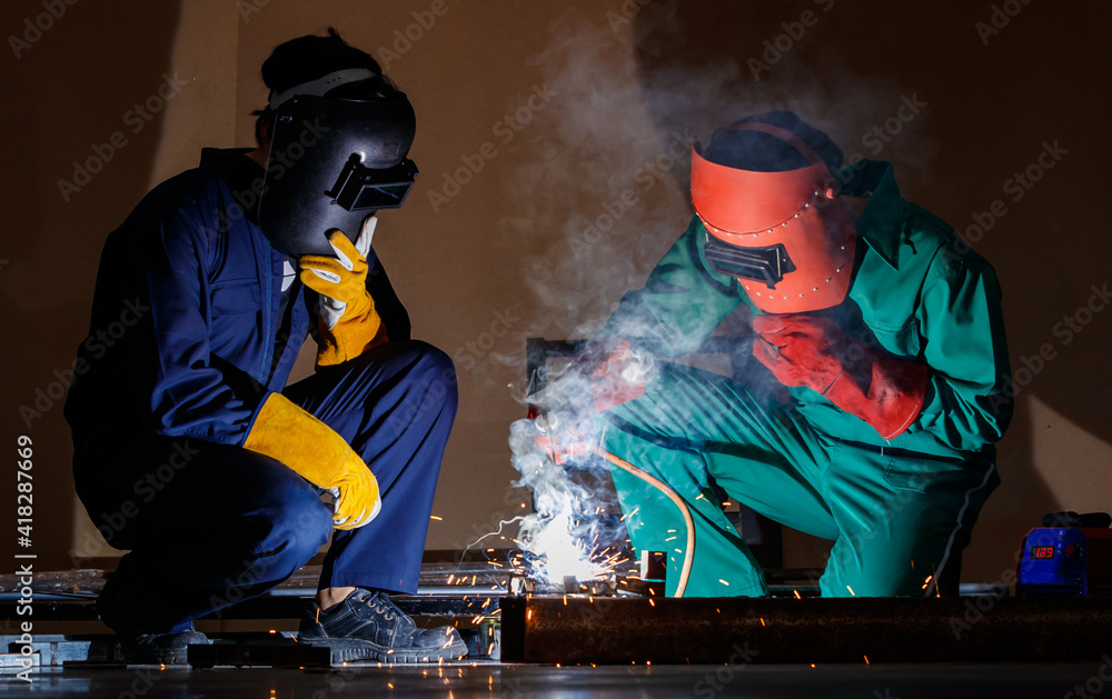 two engineers working in the dark at nighttime. Mechanics wearing a ...