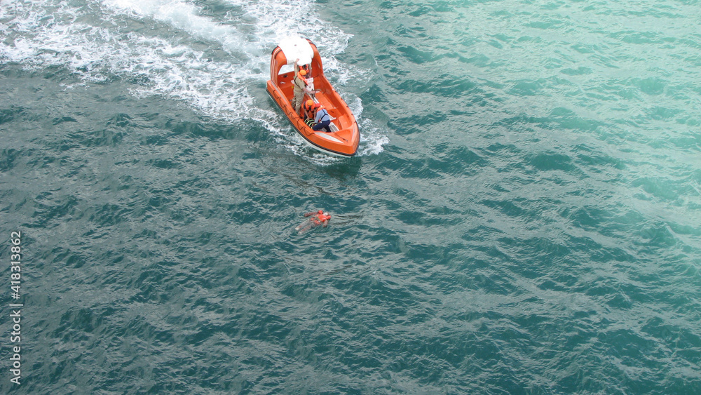 sea rescue boat with man floating in water with life jacket drowning ...
