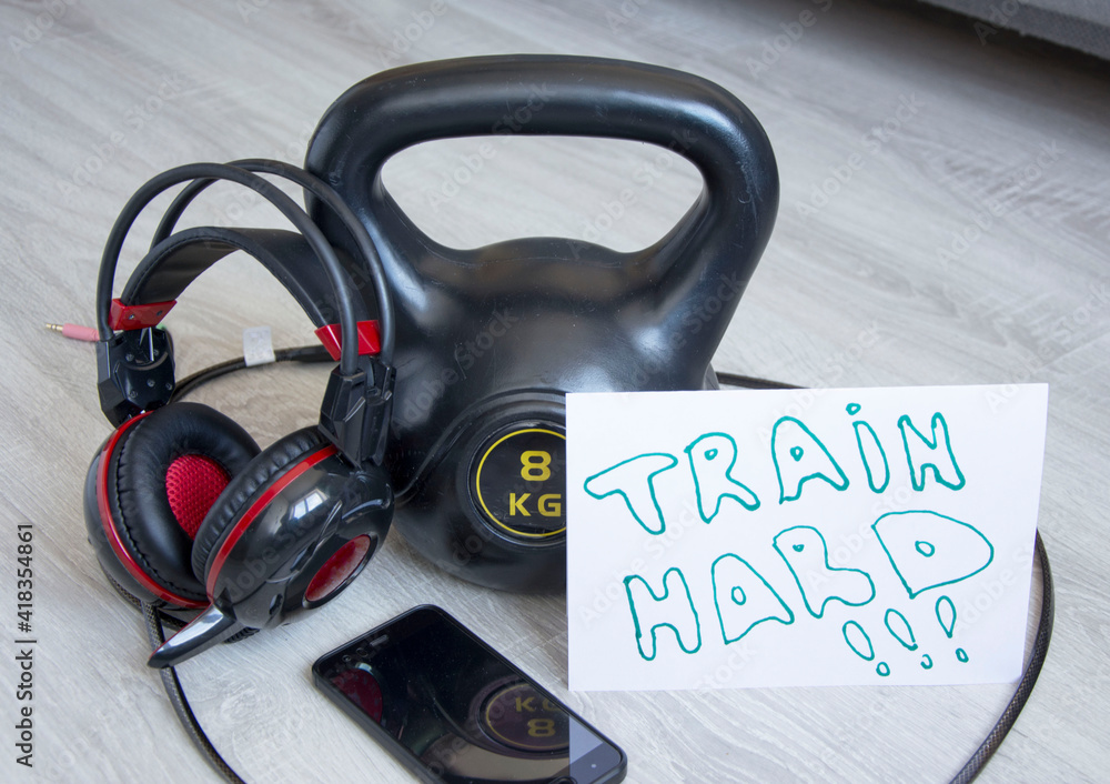 Gym kettlebell with music headphones and motivational poster /Train ...