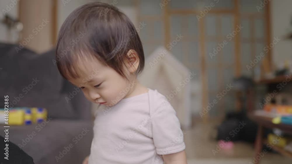 Asian baby girl standing inside apartment livingroom, child support, 2 ...