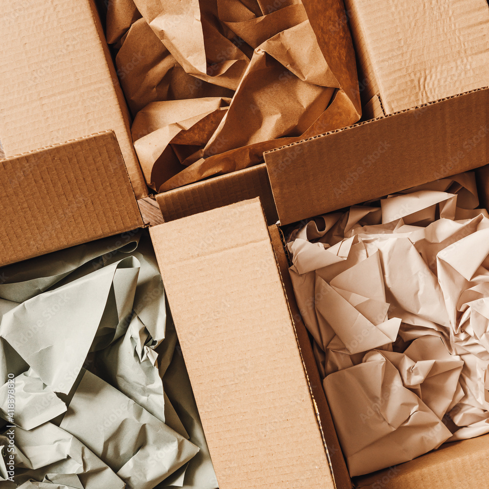 Cardboard boxes with crumpled paper inside for packaging goods from online stores, eco friendly ...