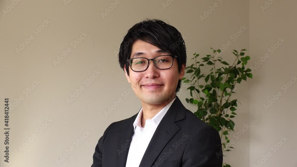 Young Asian (Japanese) business man wearing a suit at the office. One ...