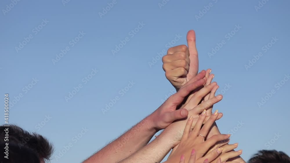 A group of friends raising their hands up to the blue sky, join them ...