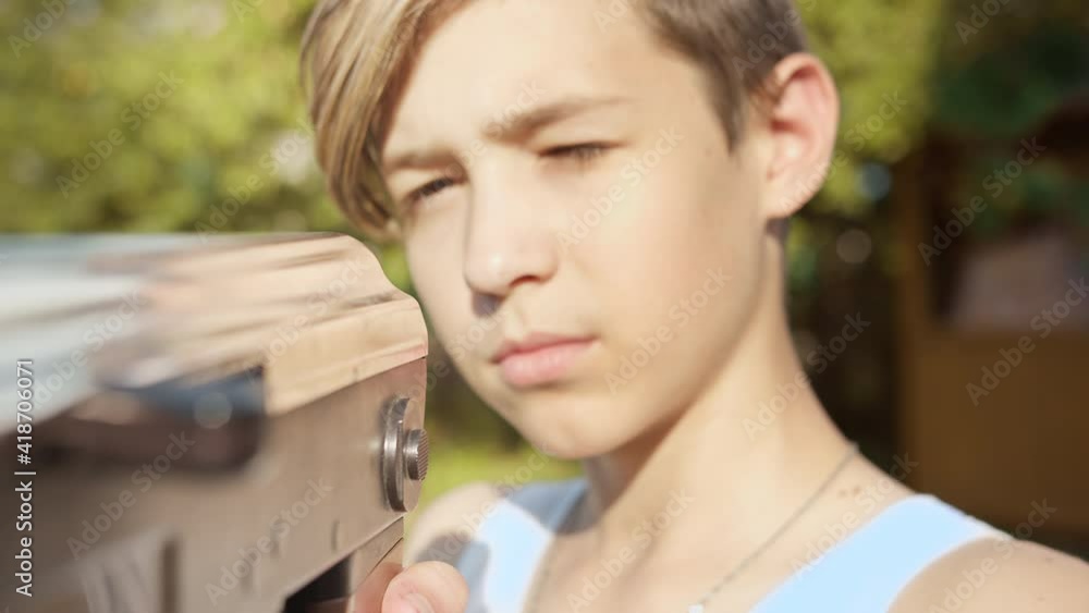 portrait of a serious boy reloading a kalashnikov assault rifle ...