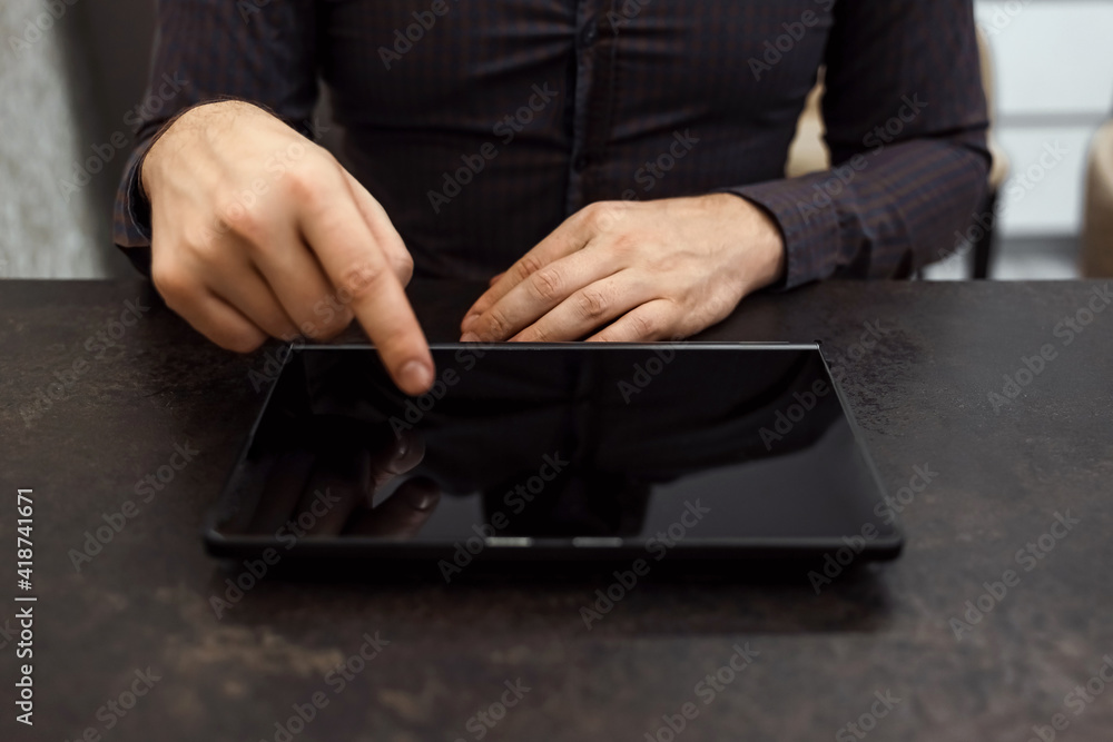 Male hands, finger pressing movements on a blank screen on a tablet ...
