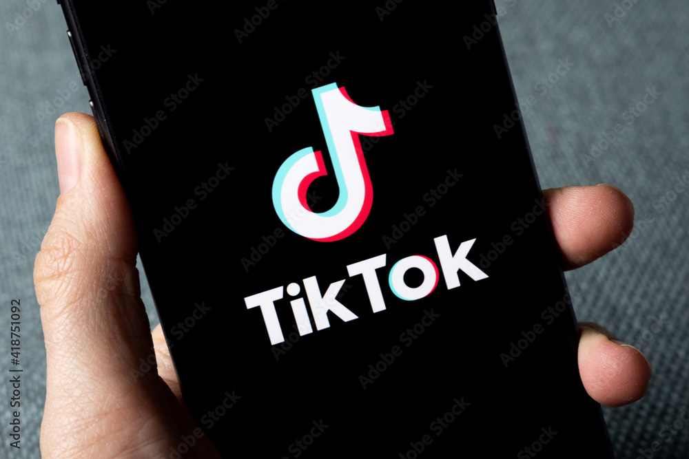 TikTok application icon on Apple iPhone 11 screen close-up. Hand ...