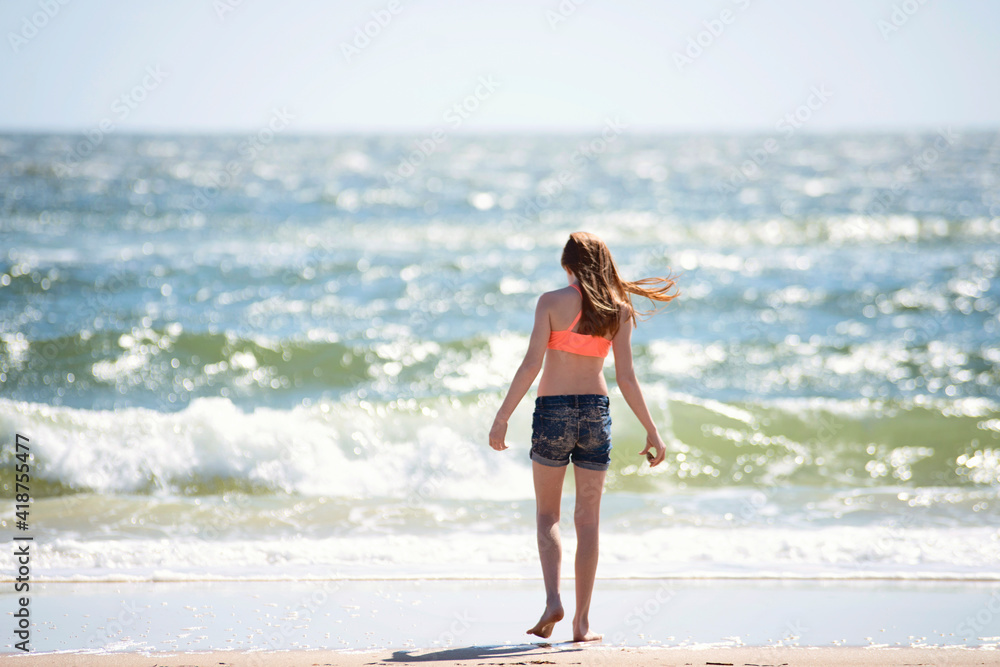 Tween red haired girl in swimsuit at the beach. Stock Photo | Adobe Stock