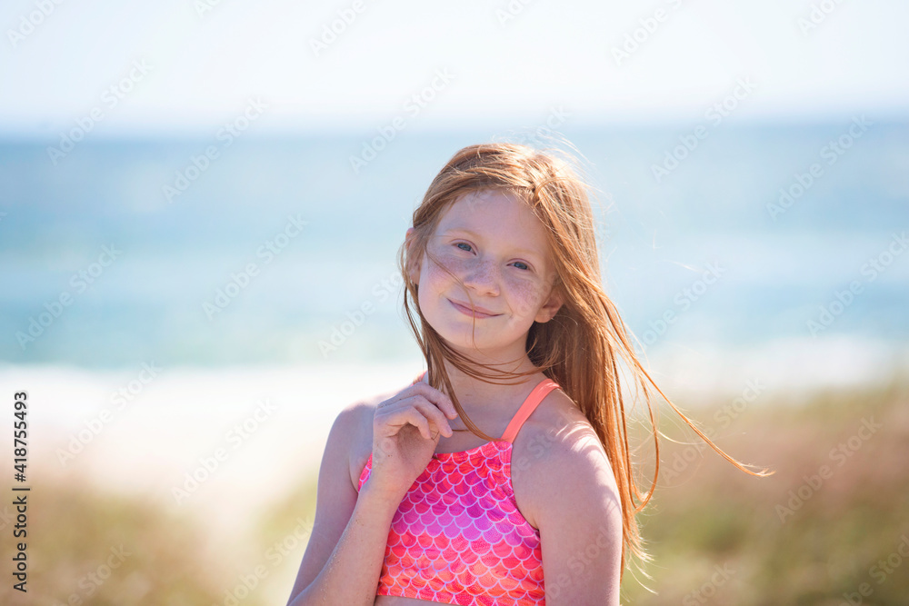 Tween red haired girl in swimsuit at the ocean. Stock Photo | Adobe Stock