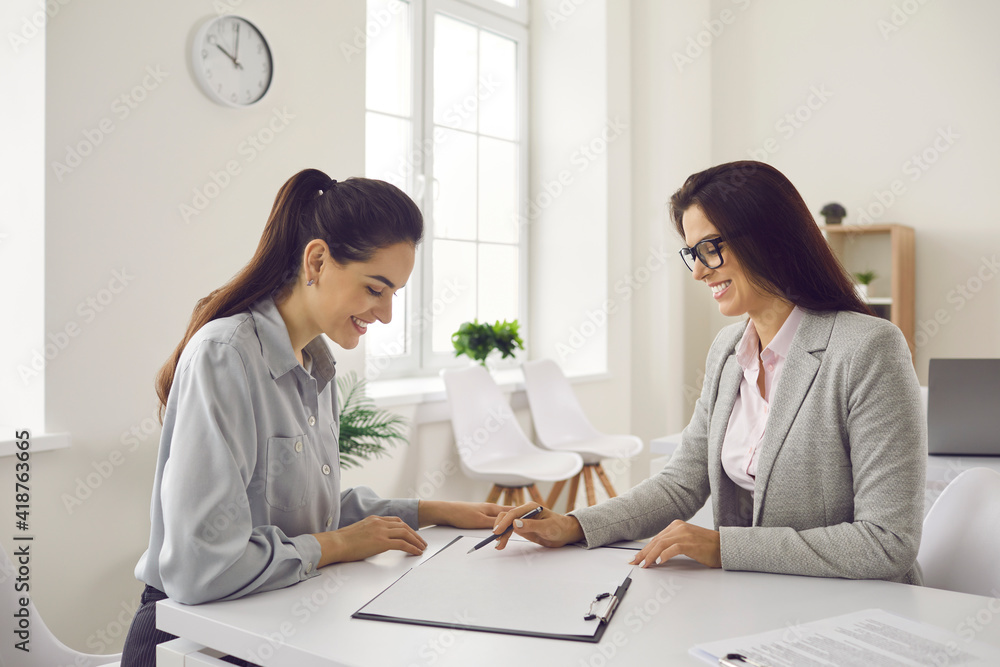 People and finance. Smiling bank manager sitting at office desk and ...