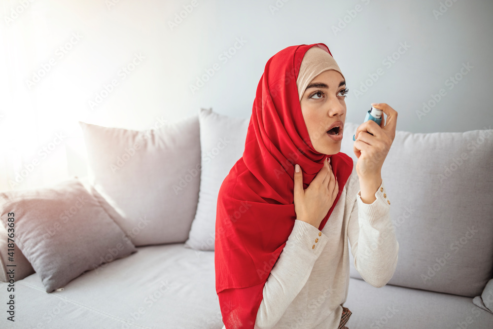 Muslim woman in hijab using inhaler at home, suffering breathing ...