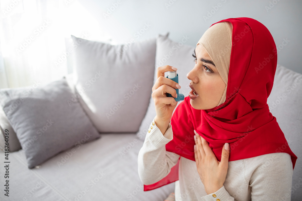 Muslim woman in hijab using inhaler at home, suffering breathing ...