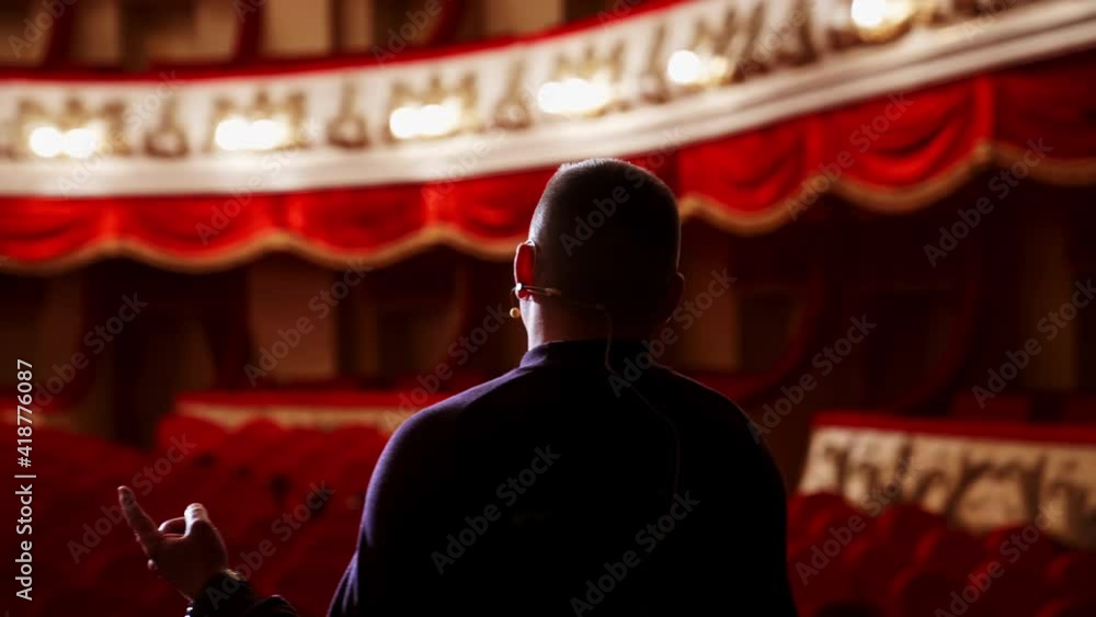 Actor rehearsing in front of empty auditorium. Back view of a man on ...