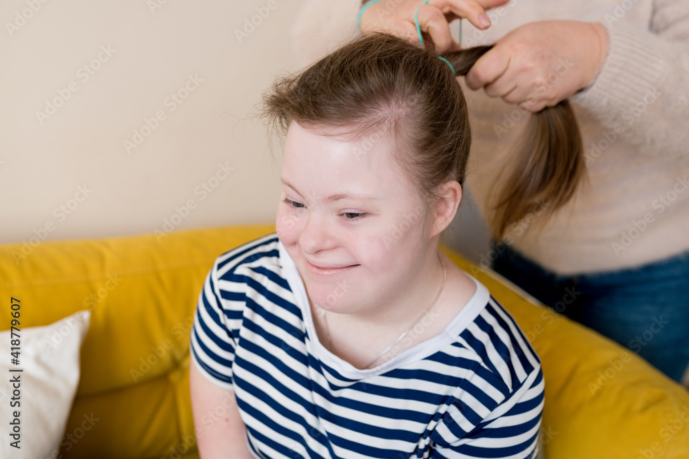 Close-up of mother s hand tying the kid hair in ponytail at home. Mom ...
