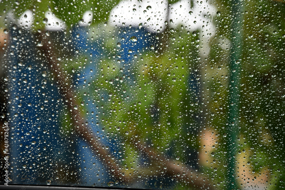 Blurry view through transparent glass window surface covered with shiny ...