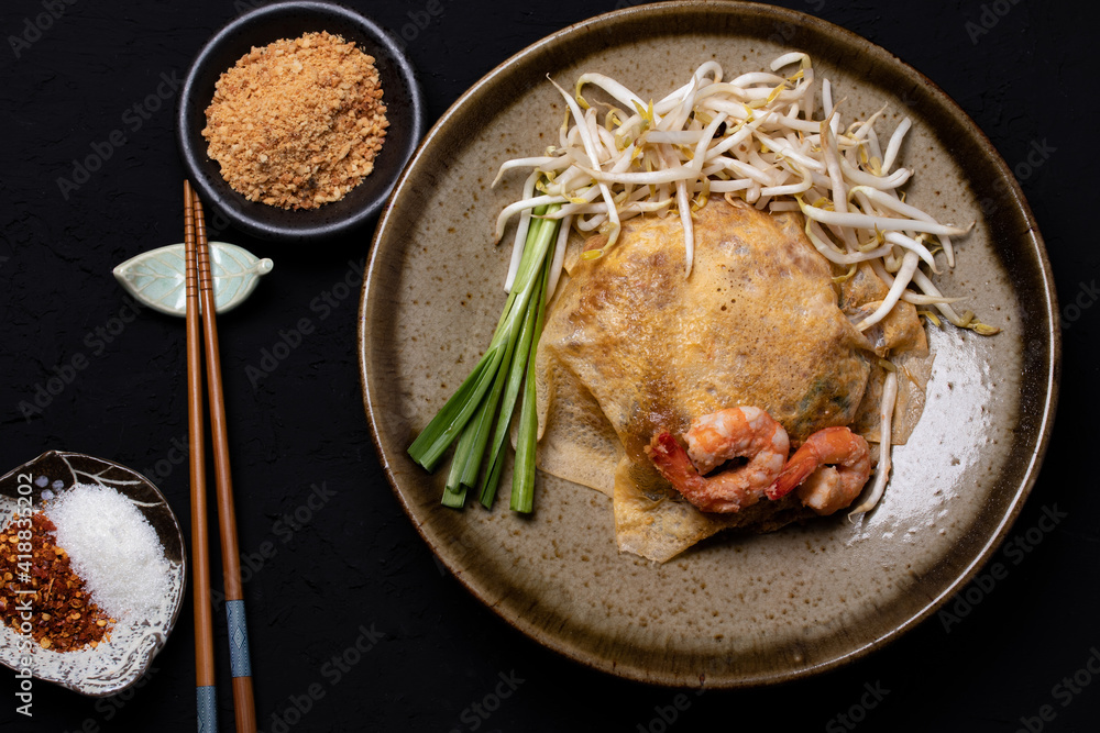 Pad Thai wrapped in egg on the black table Thai food Stock Photo ...