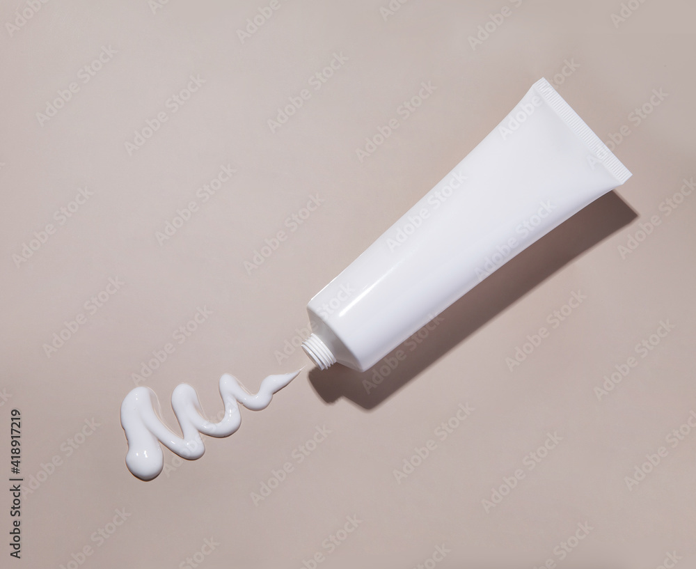 Cosmetic cream tube and stroke on beige background Stock Photo | Adobe ...