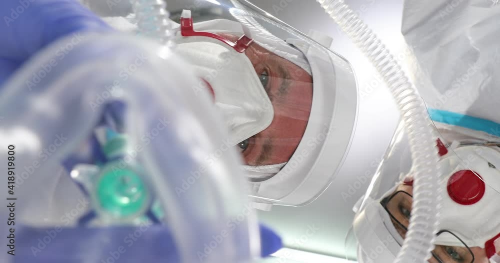Doctors in safety uniform give resuscitation to a patient in Hospital ...